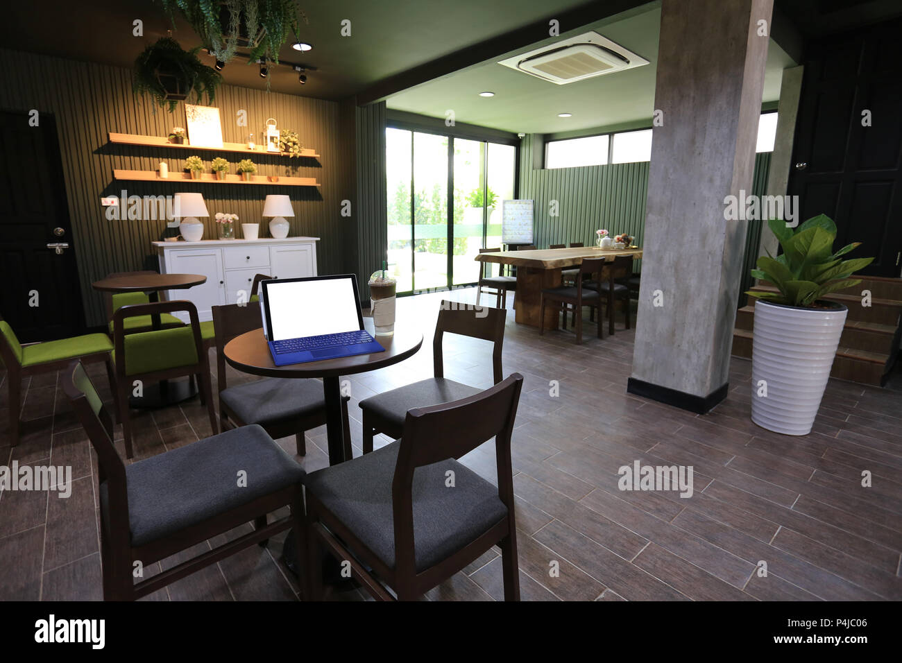 Empty screen of laptop and cold coffee mug placed on a food table in a ...