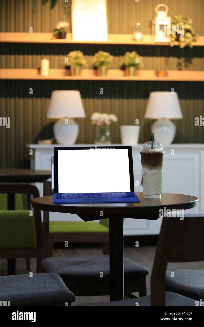 Empty screen of laptop and cold coffee mug placed on a food table in a ...