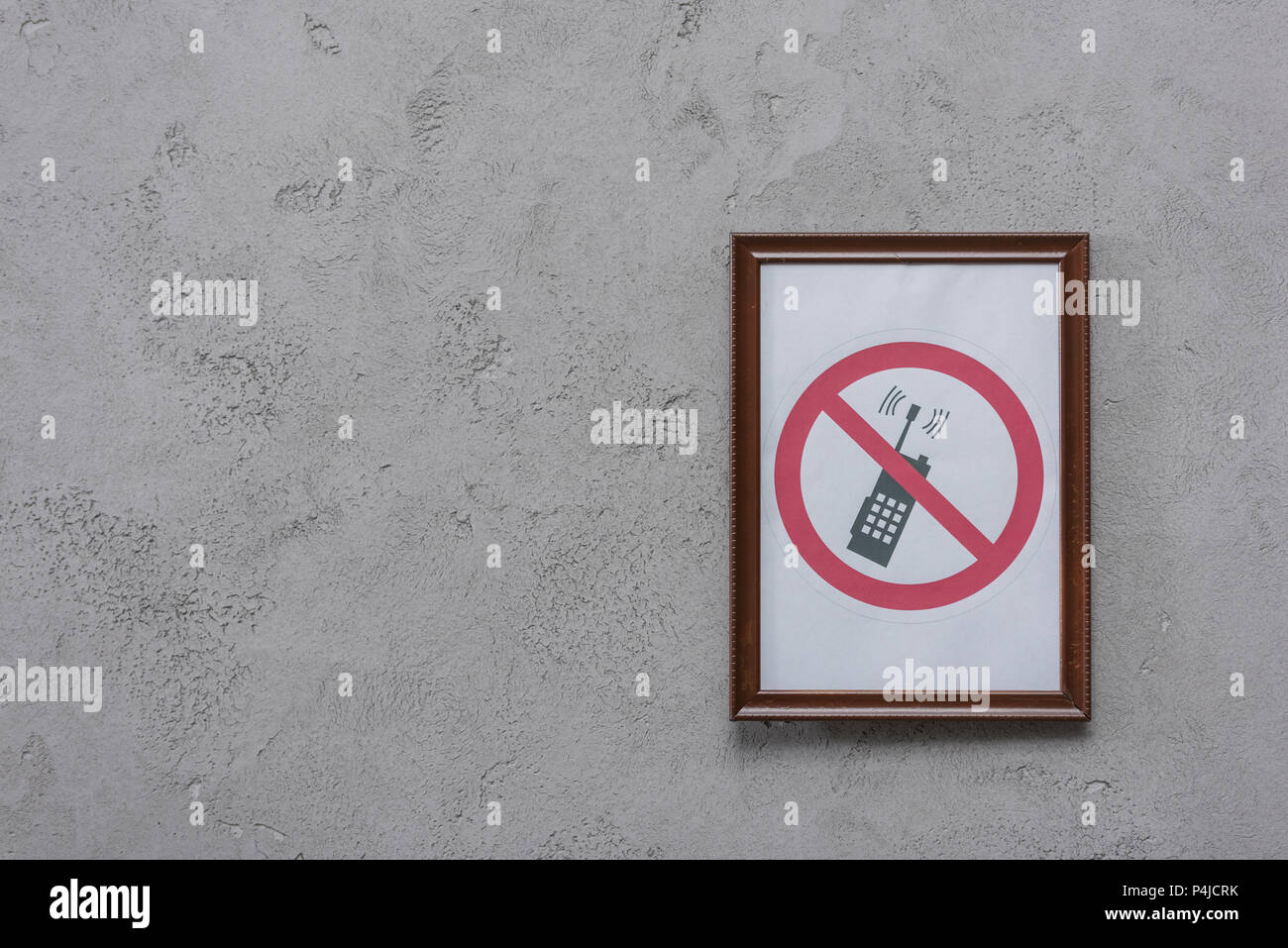 frame with restricted phone placard on concrete wall Stock Photo - Alamy