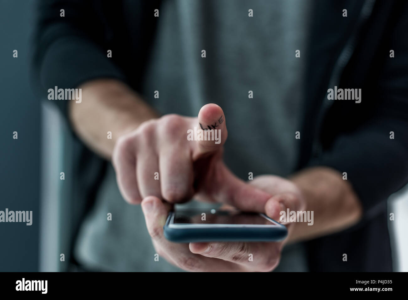 cropped shot of man touching smartphone screen with like sign on finger ...