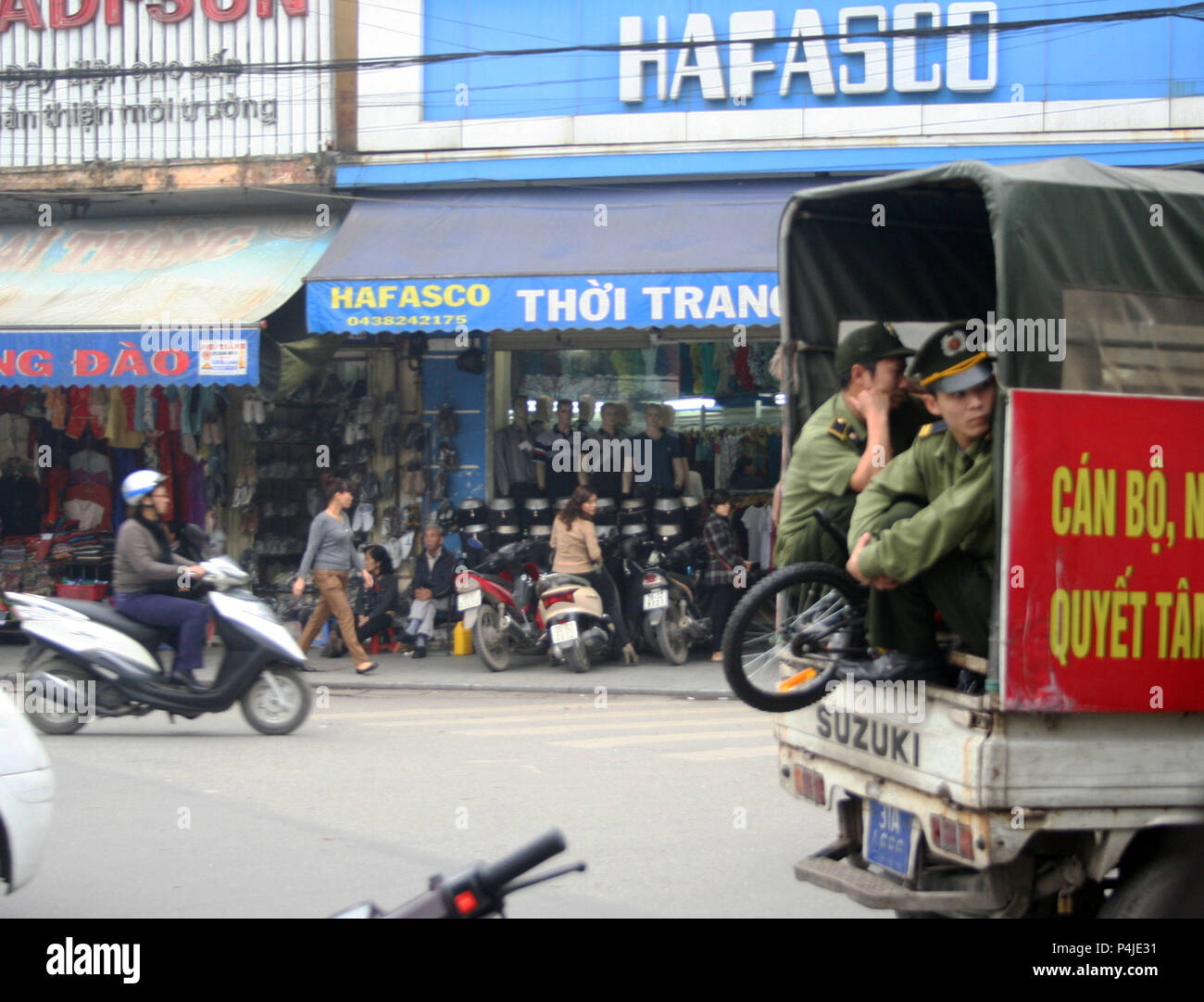 Vietnamese Police Officers looking out the back of a van, Hanoi ...