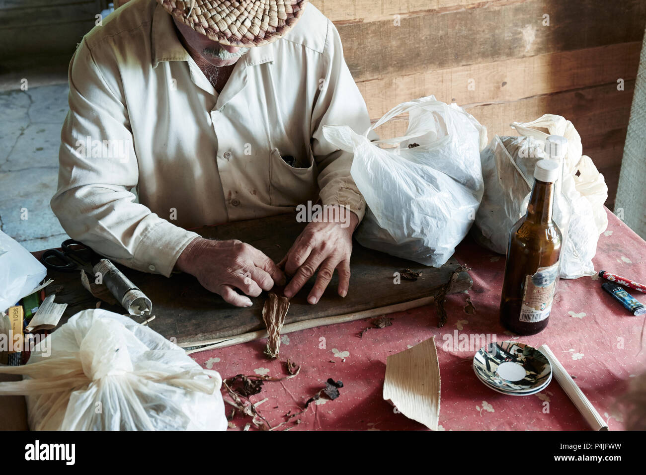 Man processing the tobacco leaves and making cigars Stock Photo - Alamy