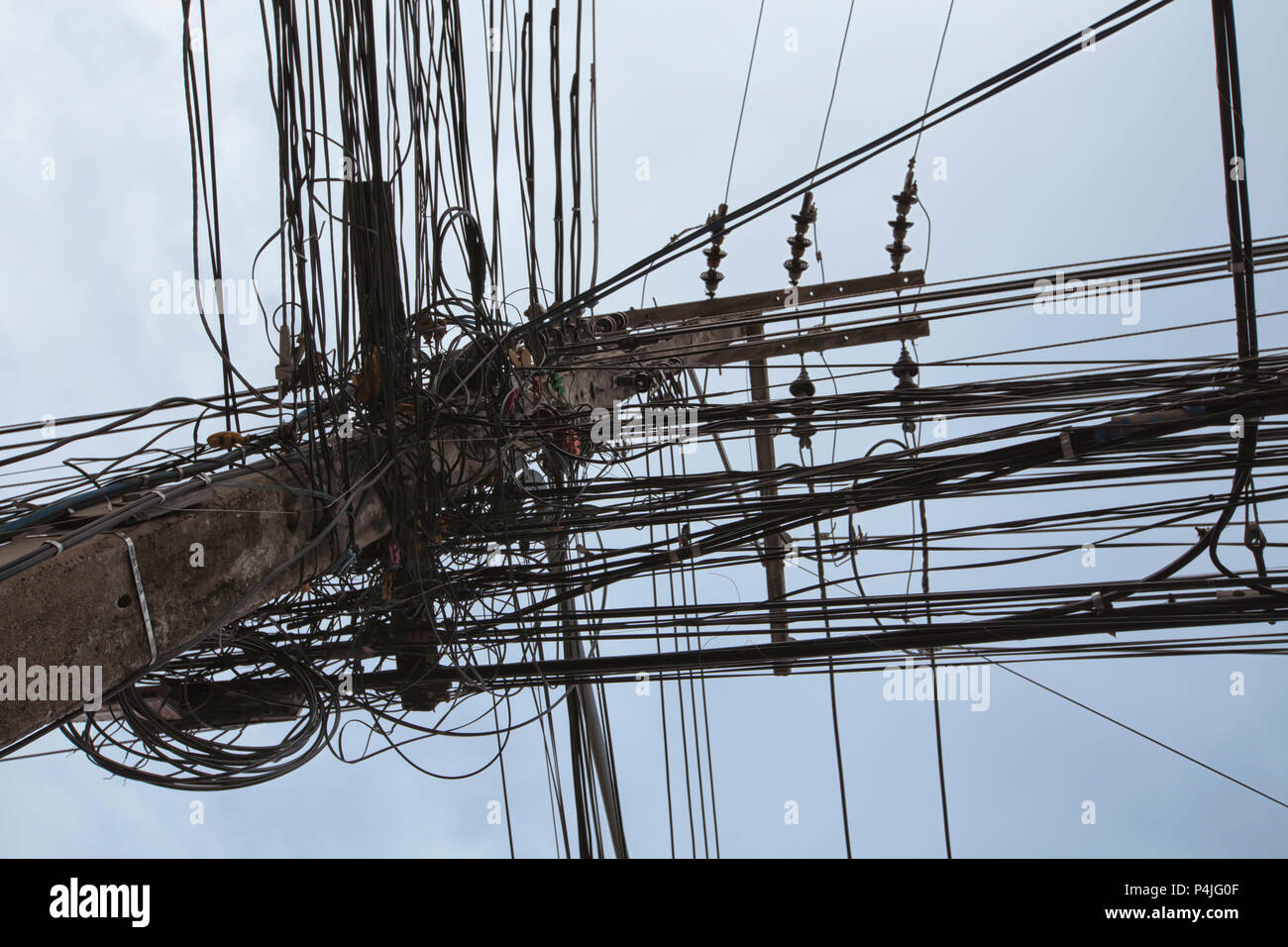 Messy wires attached to the electric pole, the chaos of cables and ...