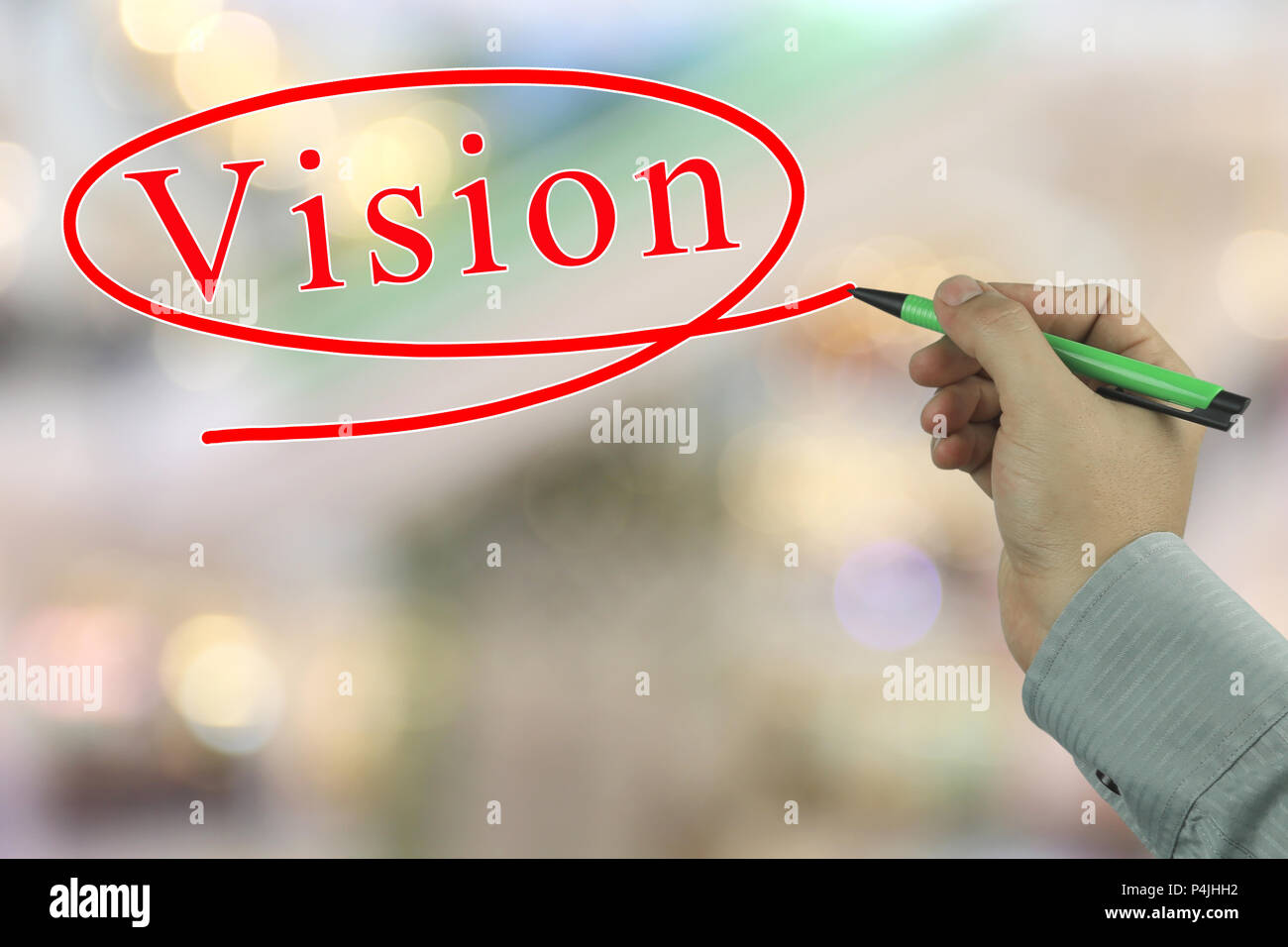 Hand of a businessman holding a red pen writing a vision text on blur ...