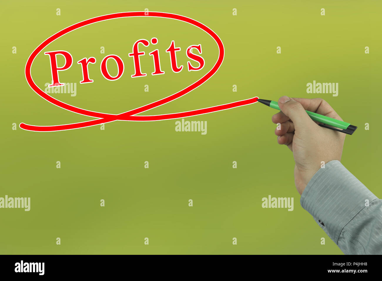 Hand of a businessman writing a profit message text on a green ...
