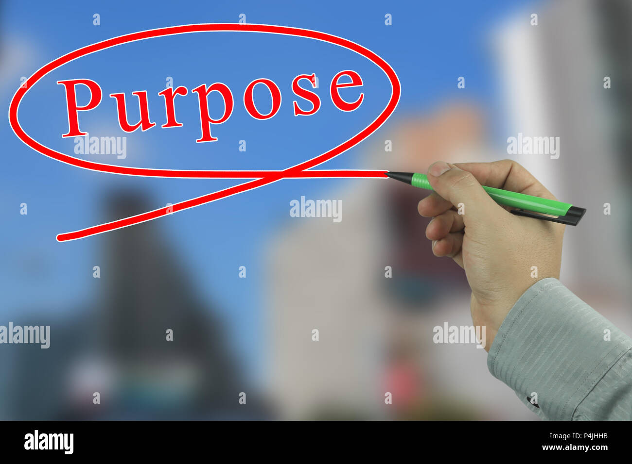 Hand of businessman writing a purpose text on blur skyscraper ...