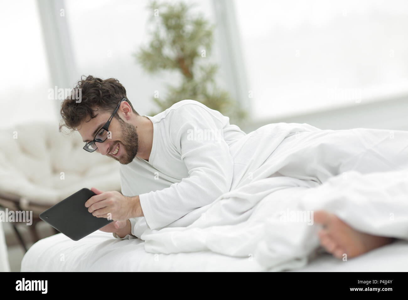 closeup.sleepy man looking at the screen of a digital tablet Stock ...