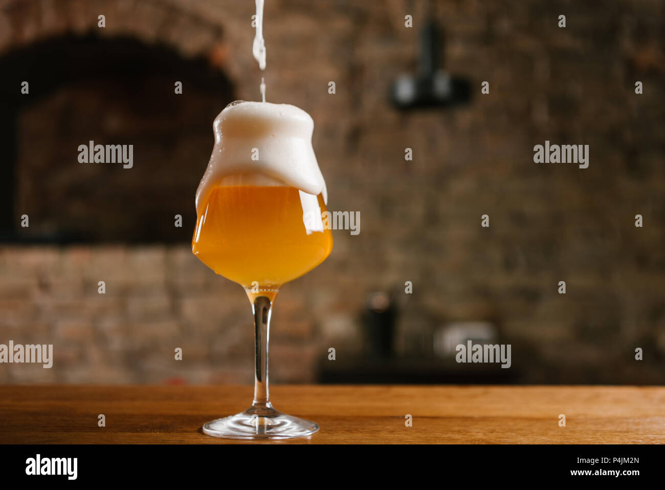 close-up view of pouring beer with foam into glass in pub Stock Photo ...