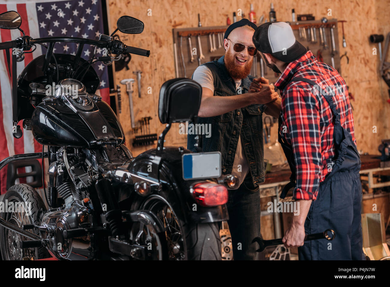 repair worker greeting customer at custom garage Stock Photo - Alamy