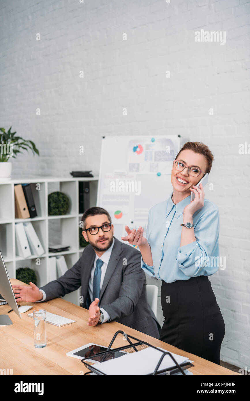 angry businessman trying to work while his colleague talking by phone ...