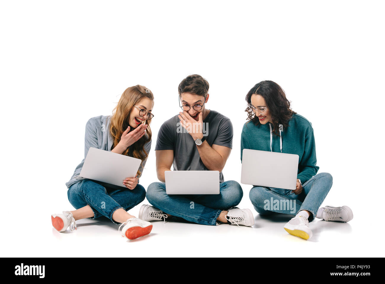 multicultural students laughing and using laptops on white Stock Photo ...