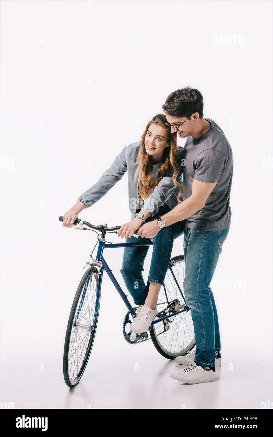 boyfriend teaching girlfriend ride bicycle on white Stock Photo - Alamy