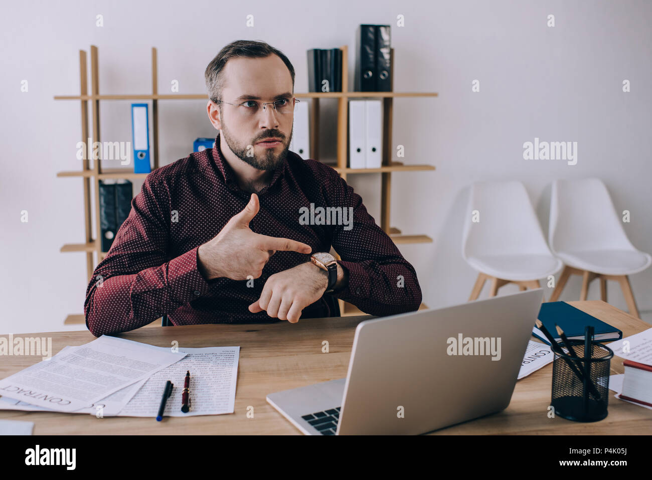 Man pointing at watch sitting hi-res stock photography and images - Alamy