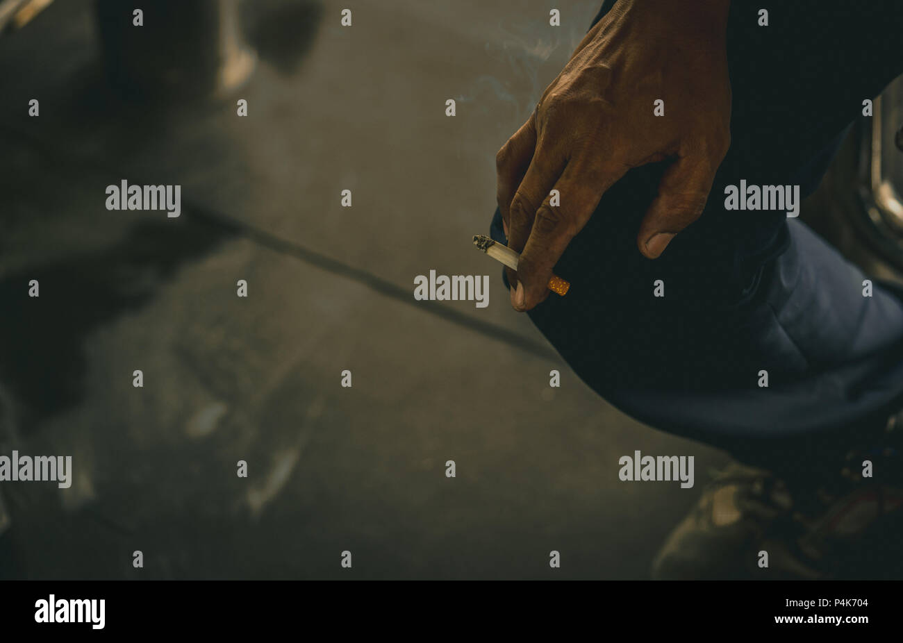 Asian man with dirty hand hold cigarette and smoke. Poor Asian men ...