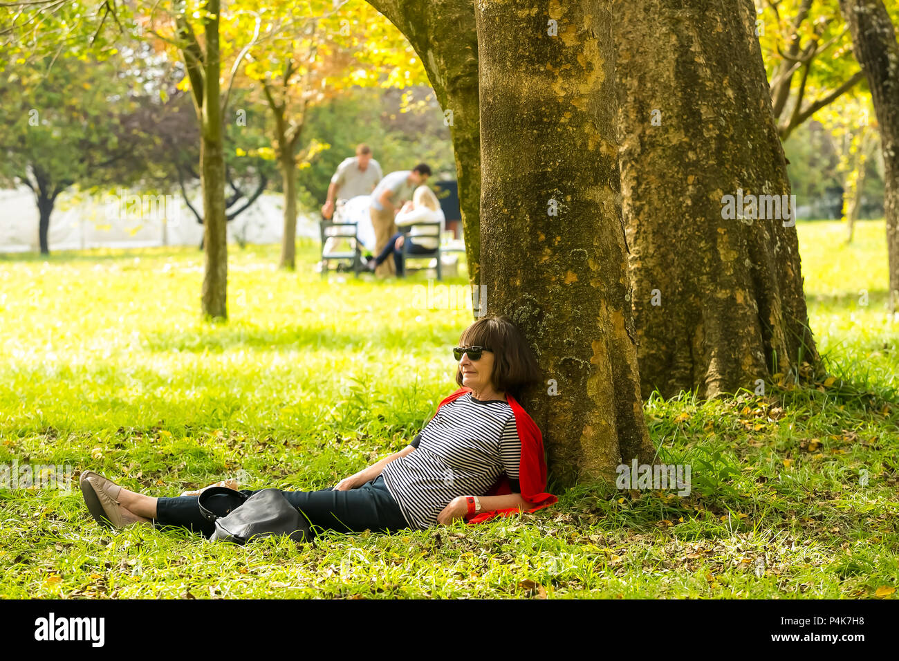 Johannesburg, South Africa, 05/10/2014, Middle aged lady lying against ...