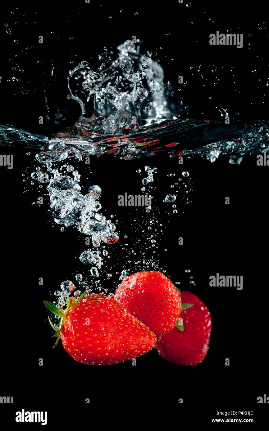 Strawberries falling in water with a splash Stock Photo - Alamy