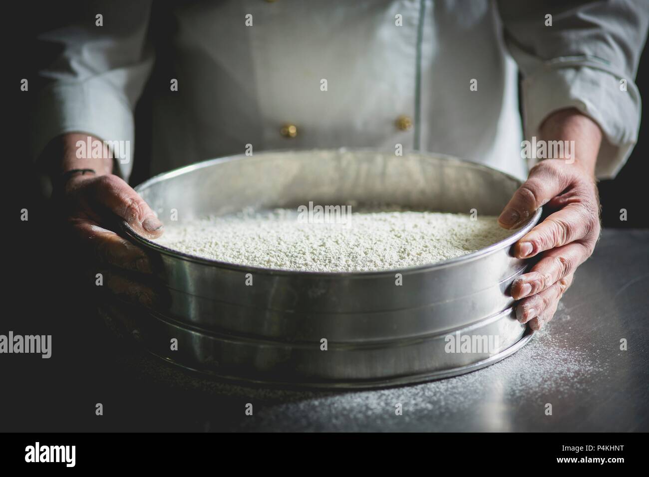 A confectioner with a large sieve of icing sugar Stock Photo - Alamy