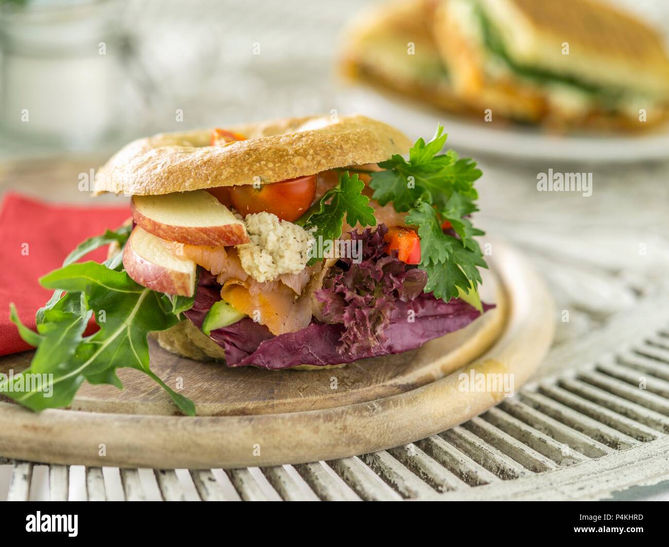 A bagel with salmon, cream cheese, lettuce, apples and tomatoes Stock ...
