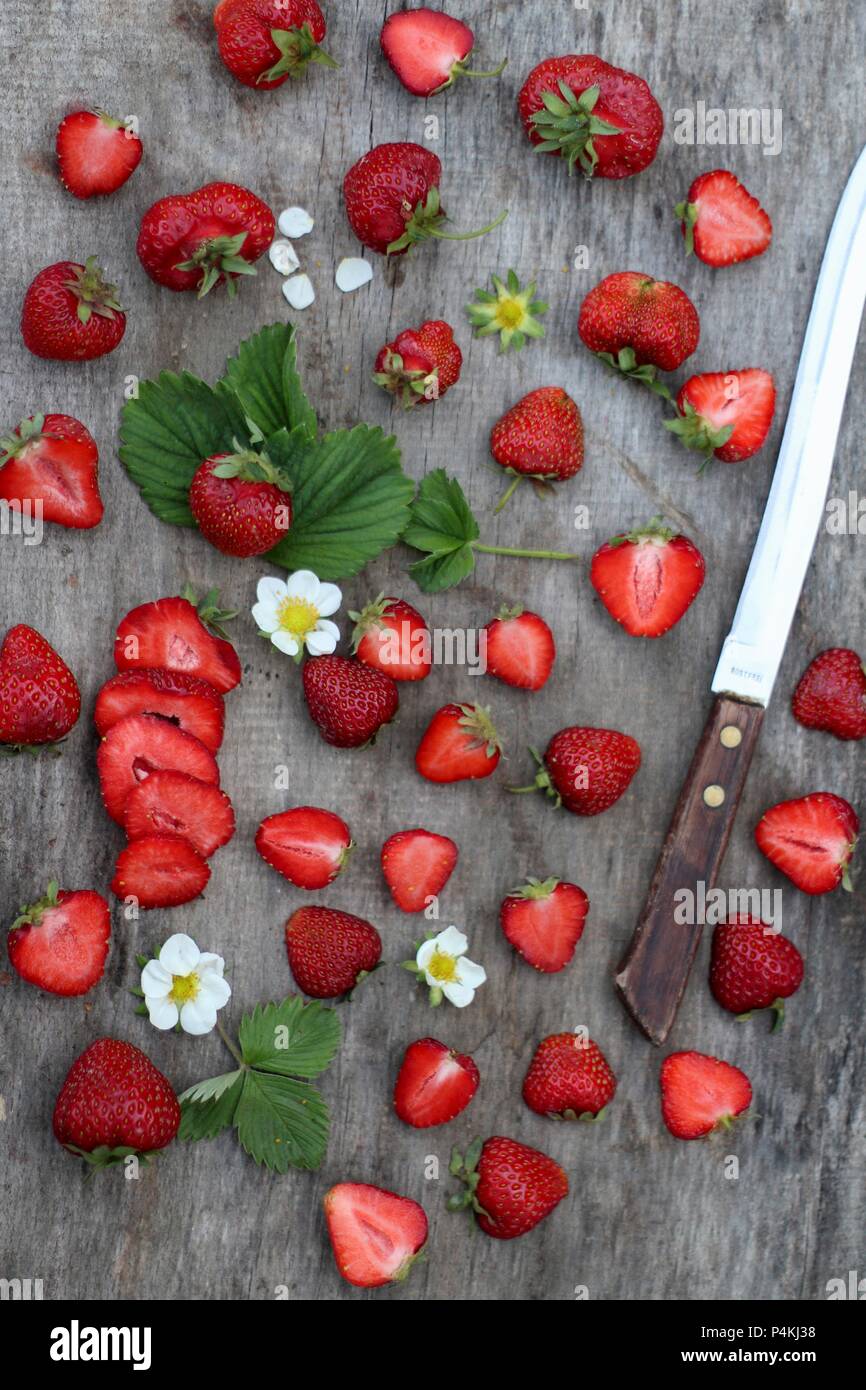 One whole and one halved strawberry hi-res stock photography and images ...