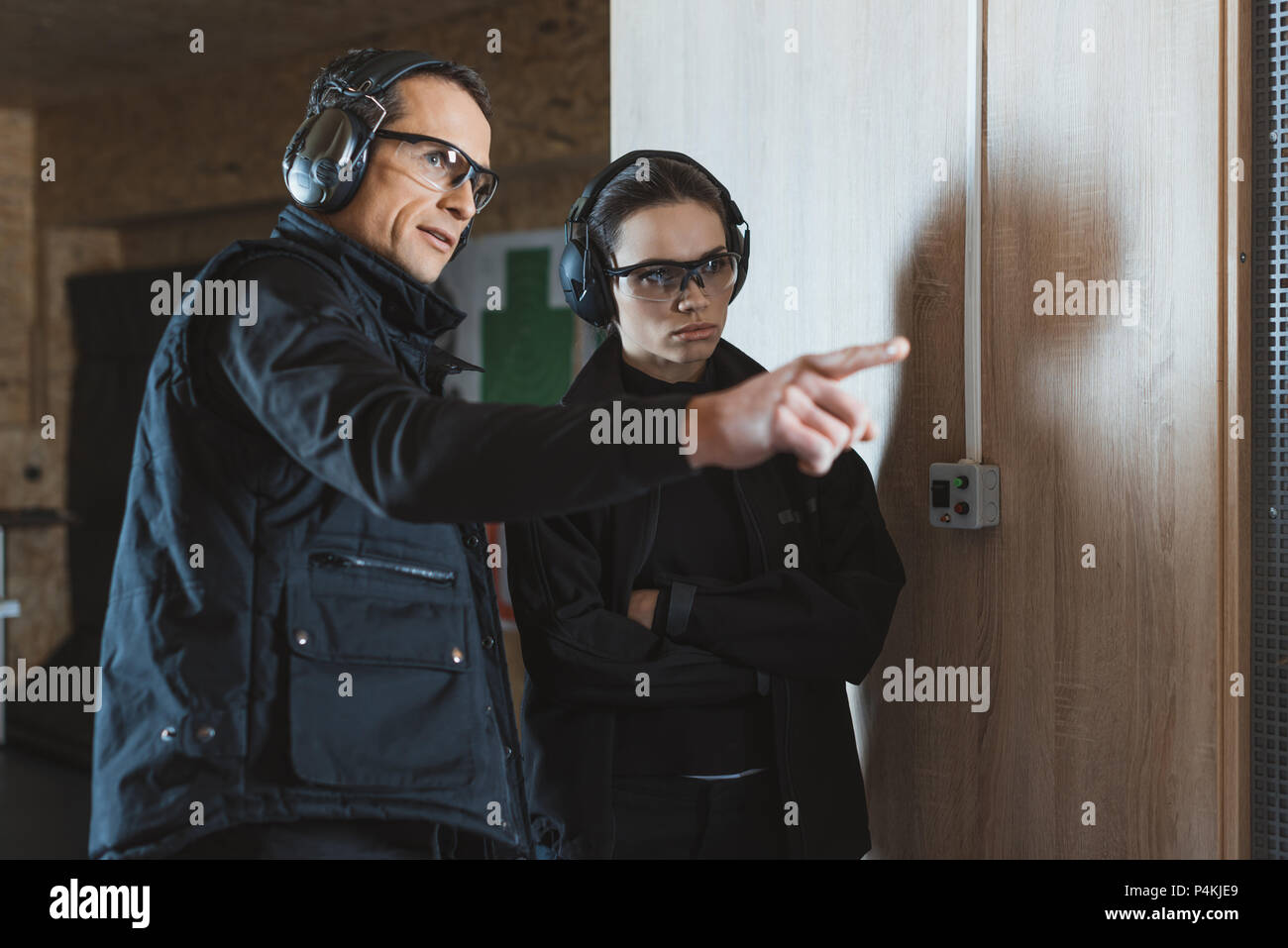 instructor pointing on something in shooting gallery Stock Photo - Alamy