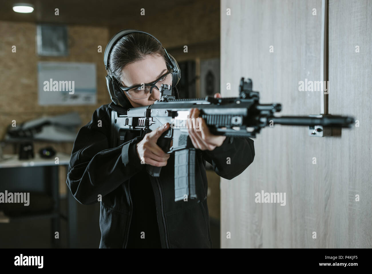 girl aiming rifle in shooting range Stock Photo - Alamy