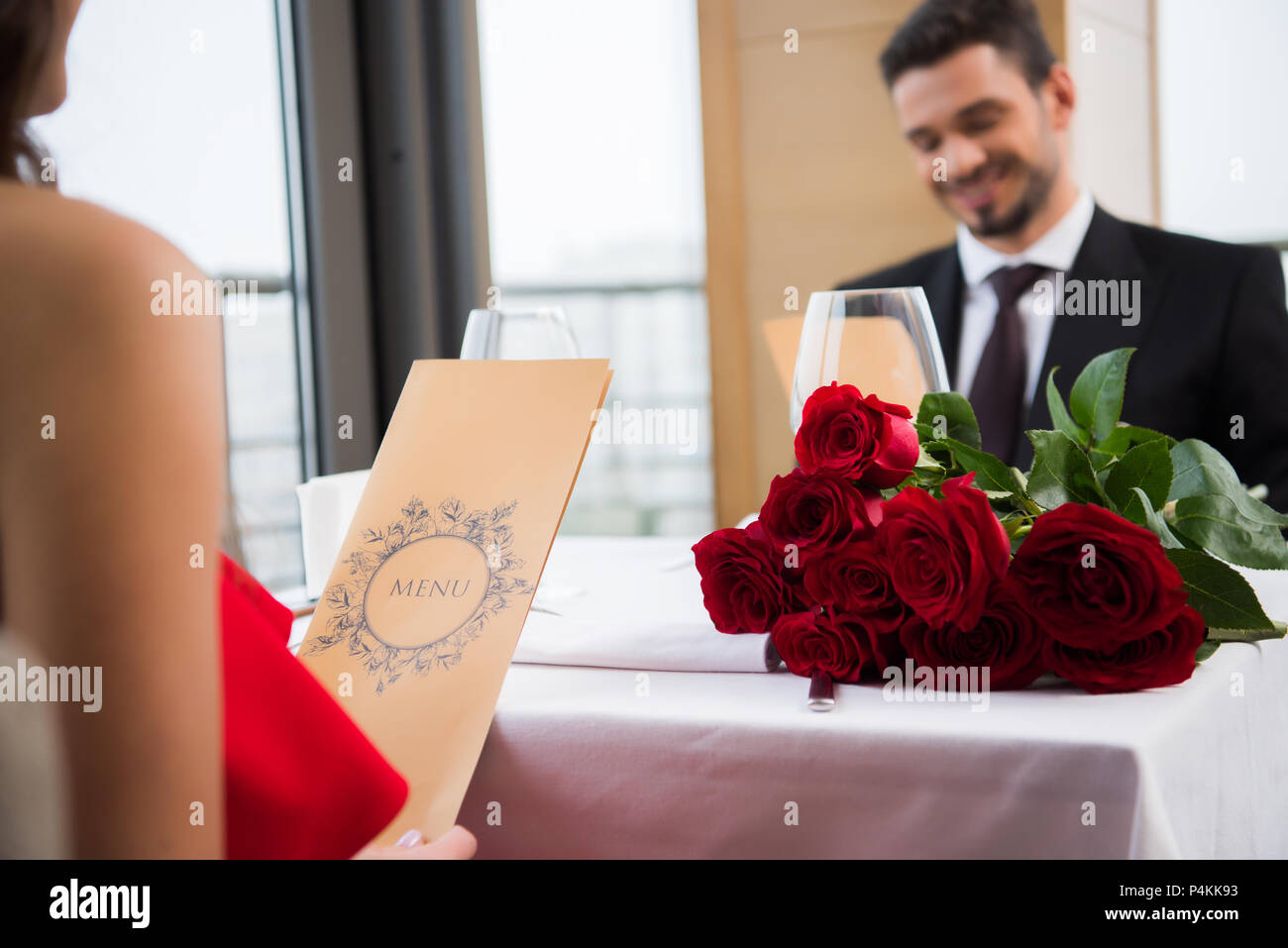 selective focus of couple reading menu on romantic date in restaurant ...