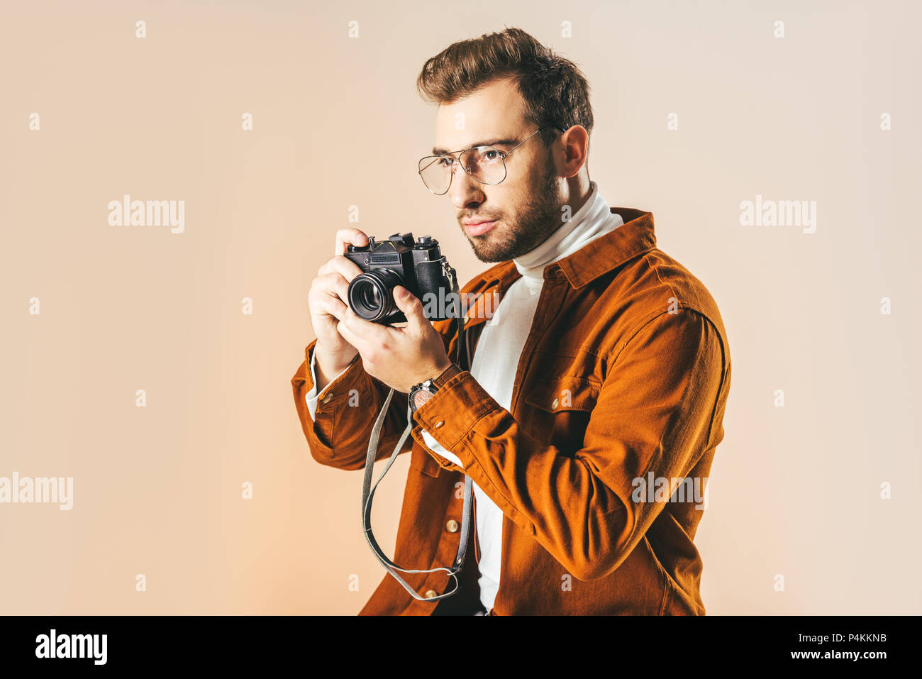 portrait of focused handsome man with photo camera in hands looking ...