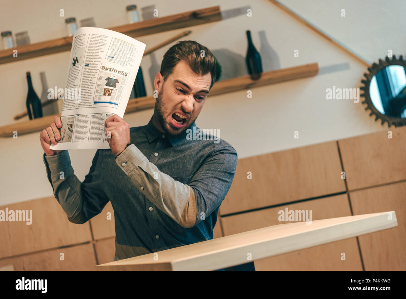 portrait of angry businessman throwing newspaper at table in cafe Stock ...