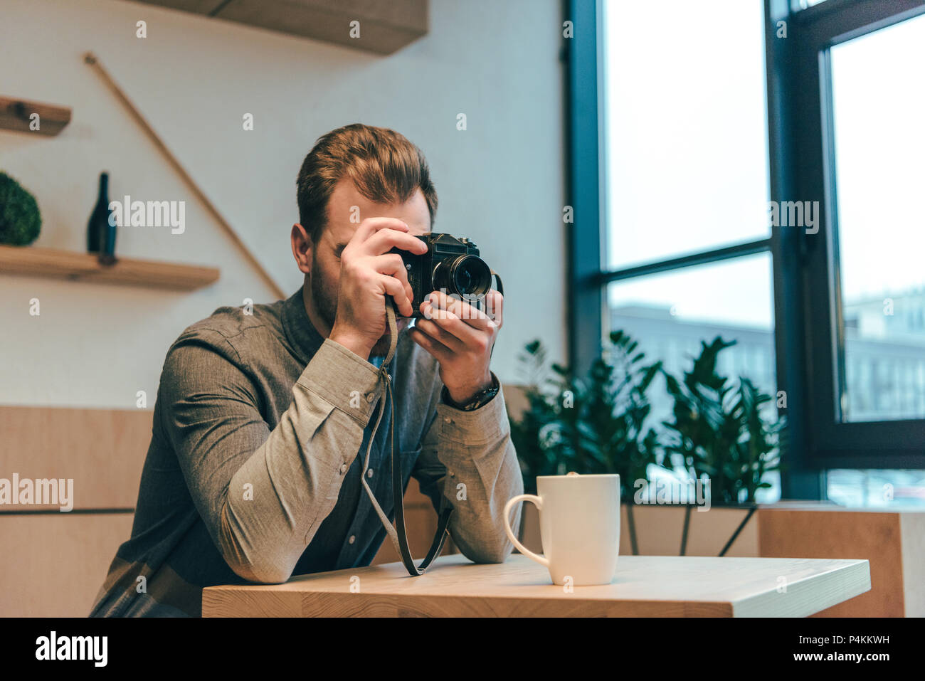 obscured view of man taking picture on photo camera in cafe Stock Photo ...