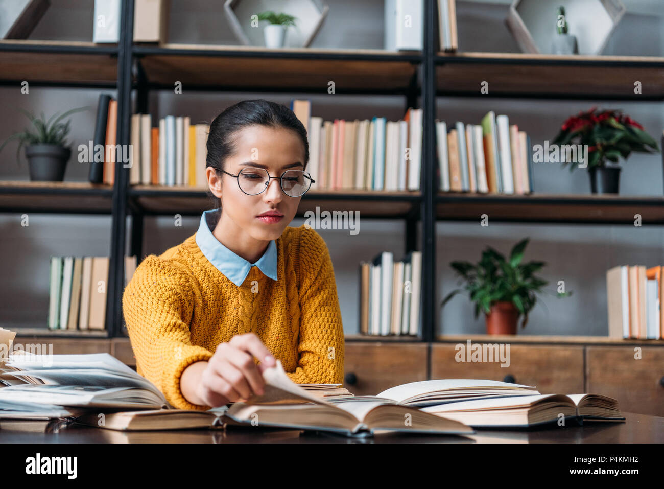 young student girl preparing for exam at library and reading book Stock ...