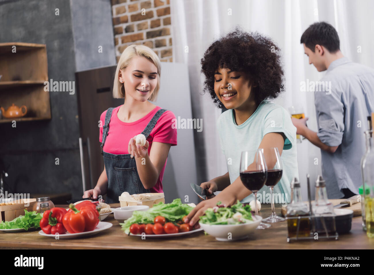 smiling multiethnic girls cooking in kitchen Stock Photo - Alamy