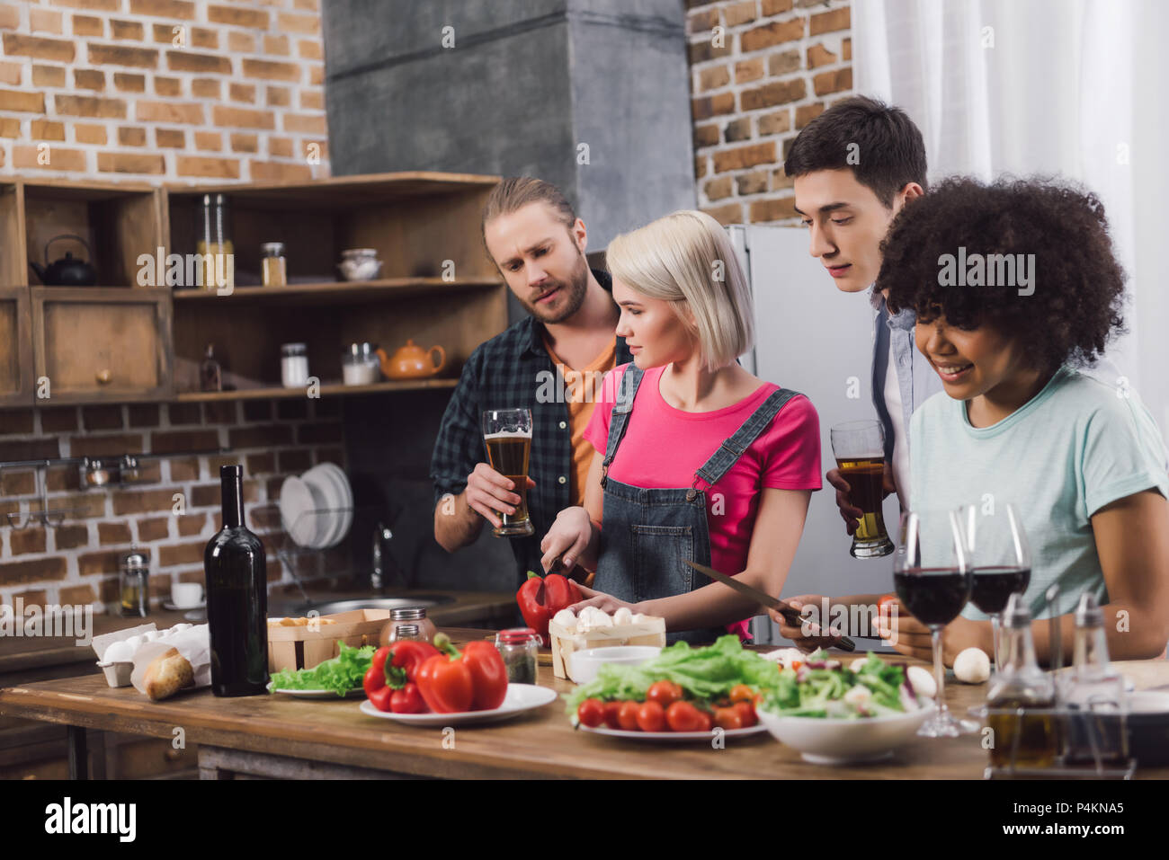 men with beer looking how multiethnic girls cooking Stock Photo - Alamy