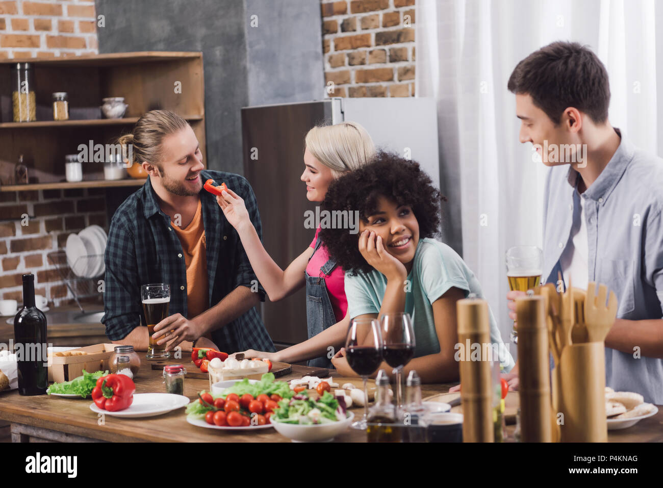 multicultural friends eating and drinking in kitchen Stock Photo - Alamy