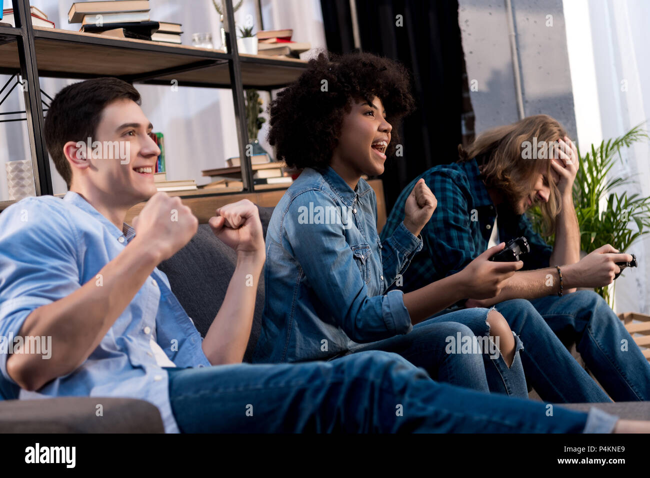 multicultural friends playing video game at home Stock Photo - Alamy