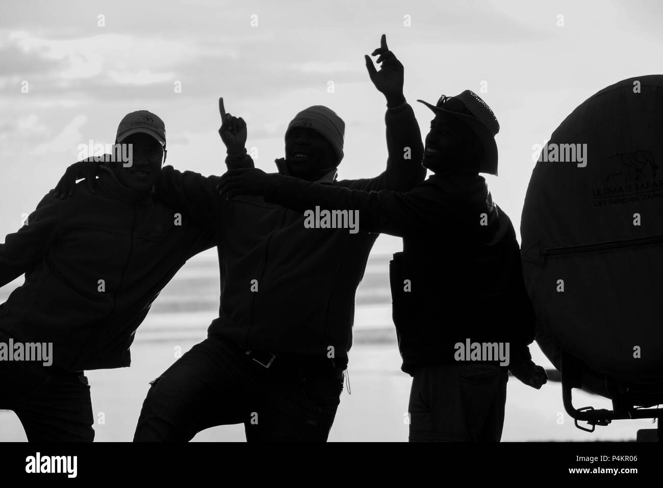 Silhouetted men back-lit by setting sun Stock Photo - Alamy