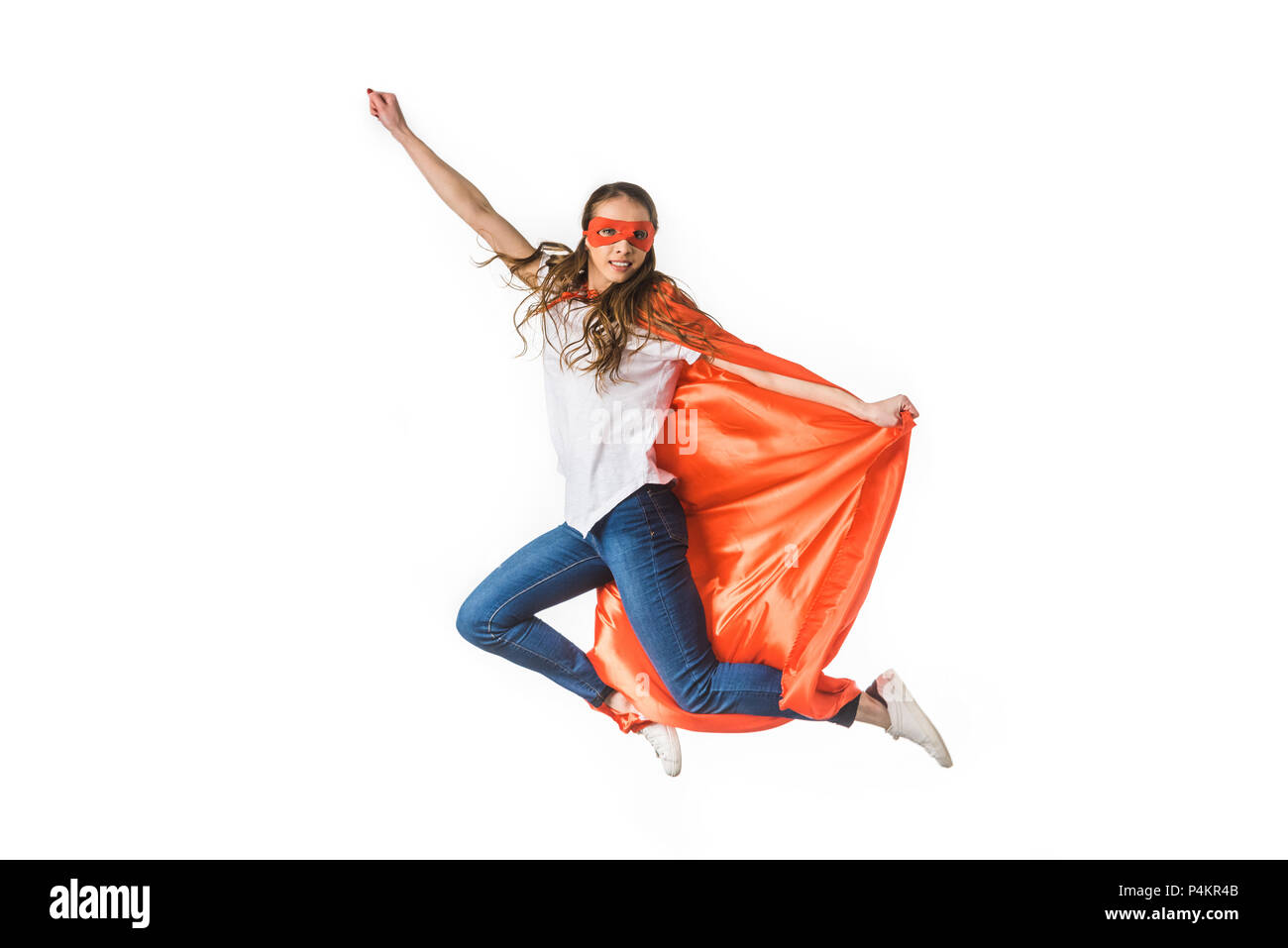 smiling young woman in red cloak and mask flying isolated on white ...