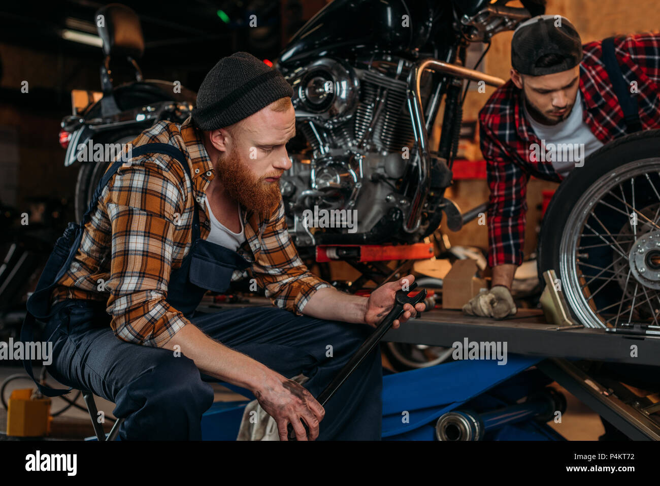 handsome mechanics working together at custom garage Stock Photo - Alamy