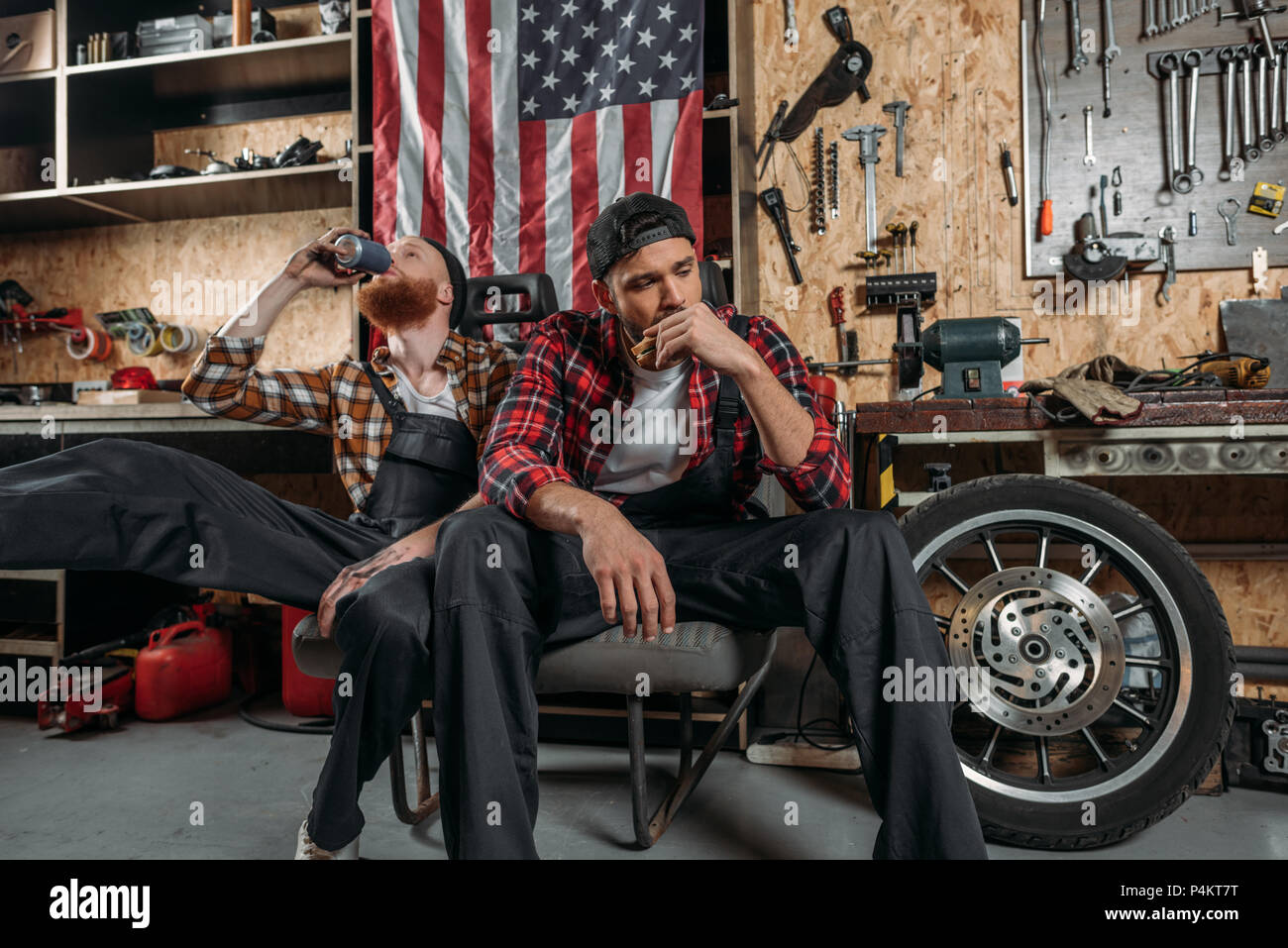 exhausted mechanics having lunch together at garage Stock Photo - Alamy