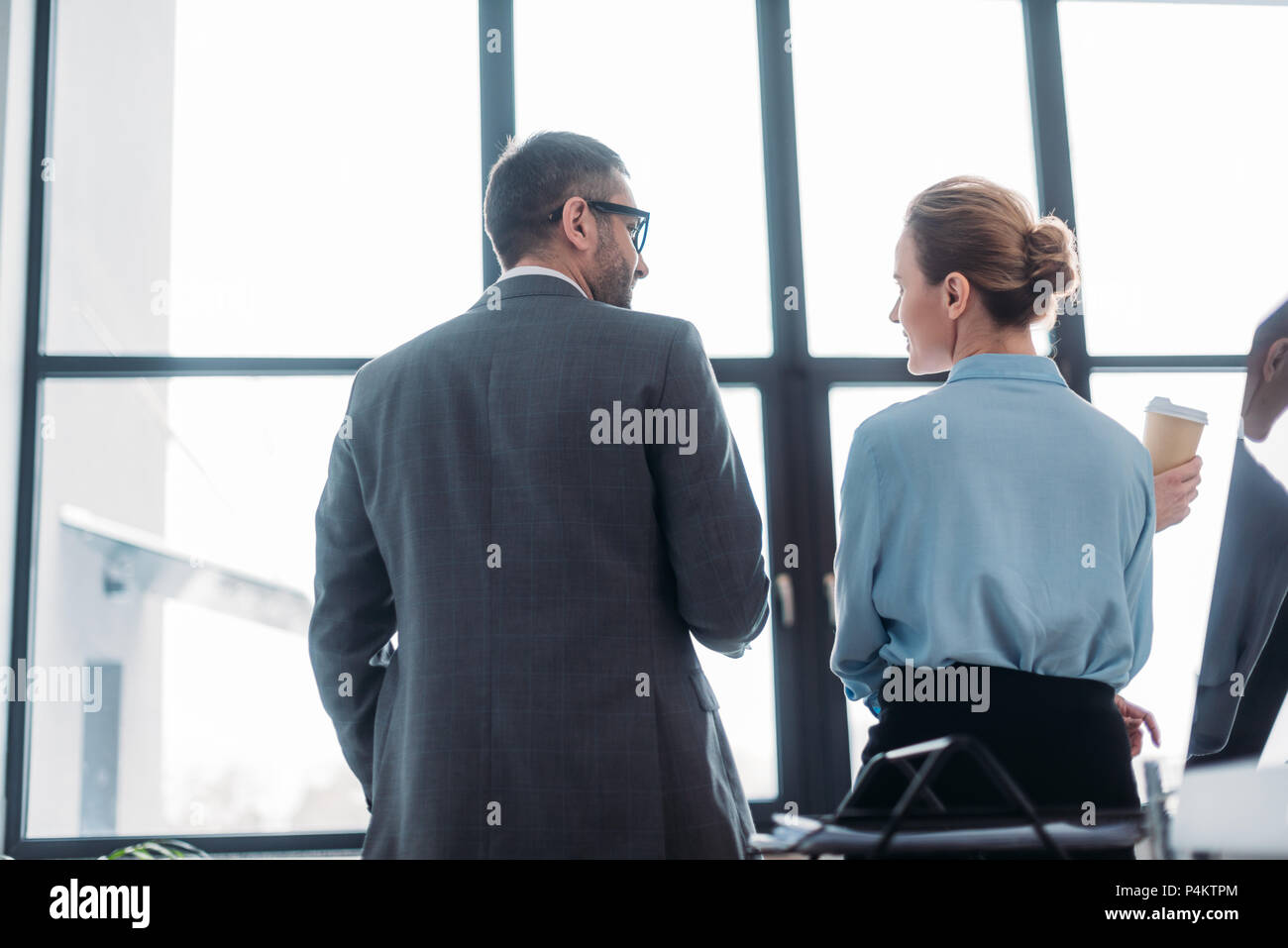 rear view of businesspeople having conversation at office and drinking ...
