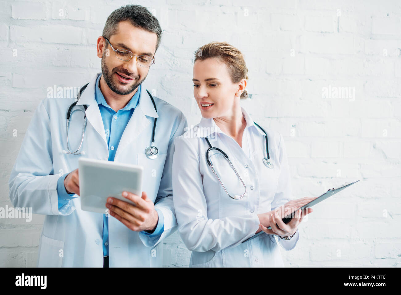 happy doctors working together with tablet and clipboard Stock Photo ...