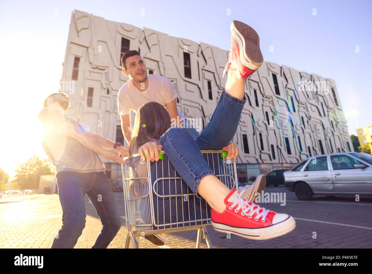 Young three person amuse with shopping cart near the super market on ...