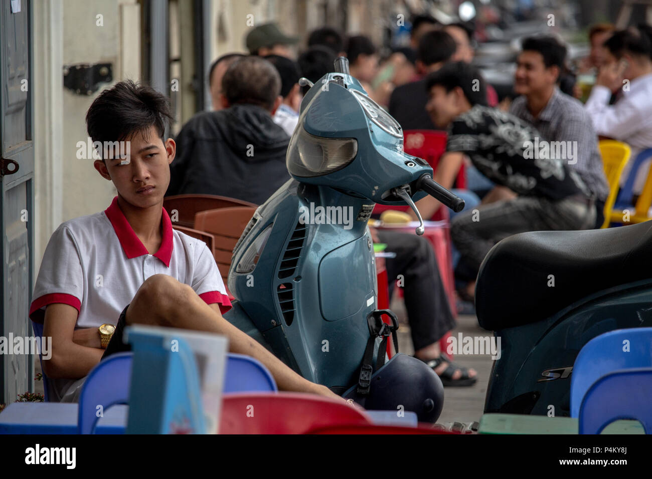 Hanoi, Vietnam - March 16, 2018: Boy sitting in a bar on the street ...