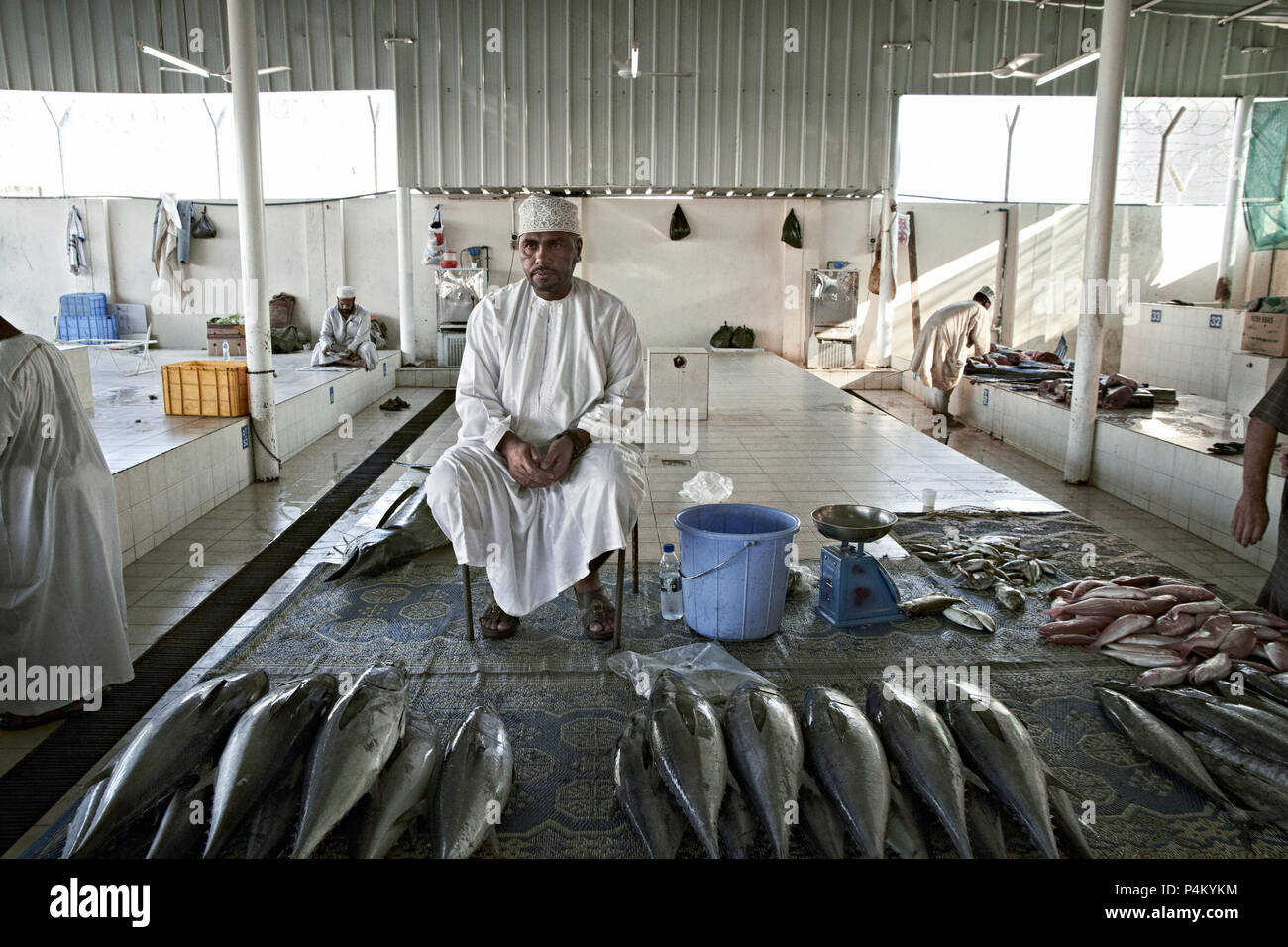 Old omani fisherman selling his catch at the old fish market in Muttrah ...