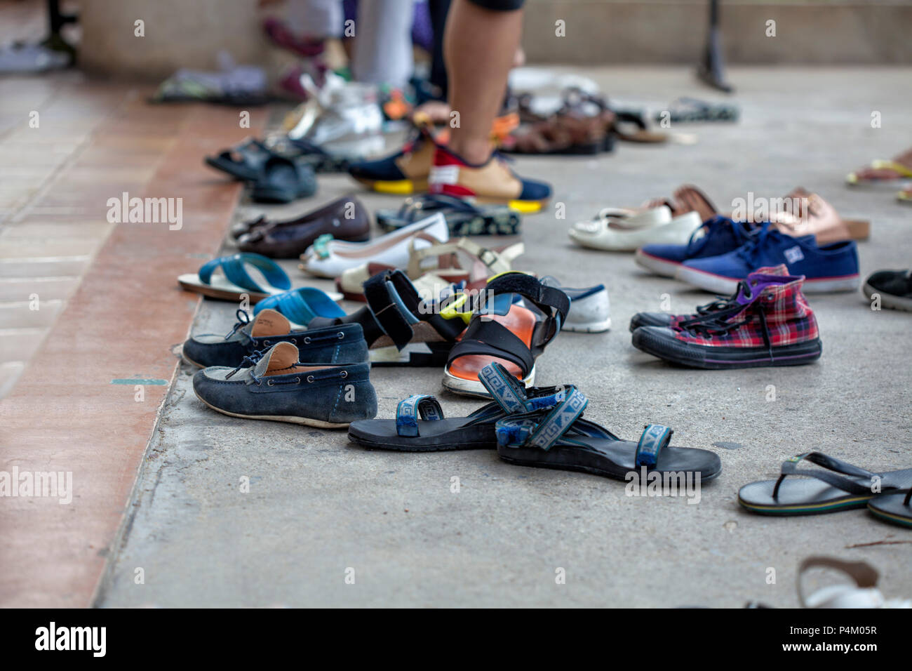 People take off their shoes on the steps in front of the entrance to a ...