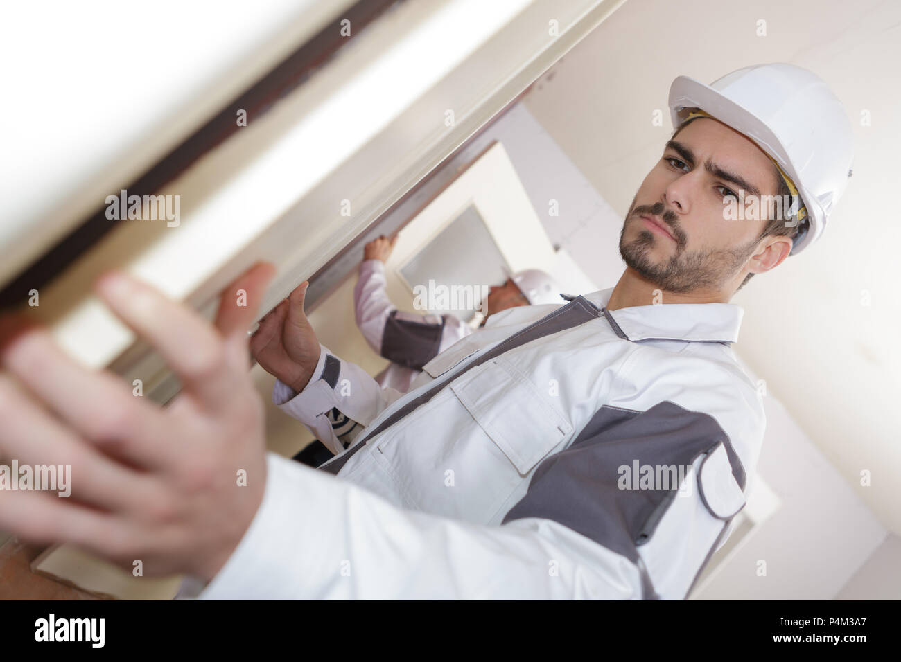 young construction worker fitting a window Stock Photo - Alamy