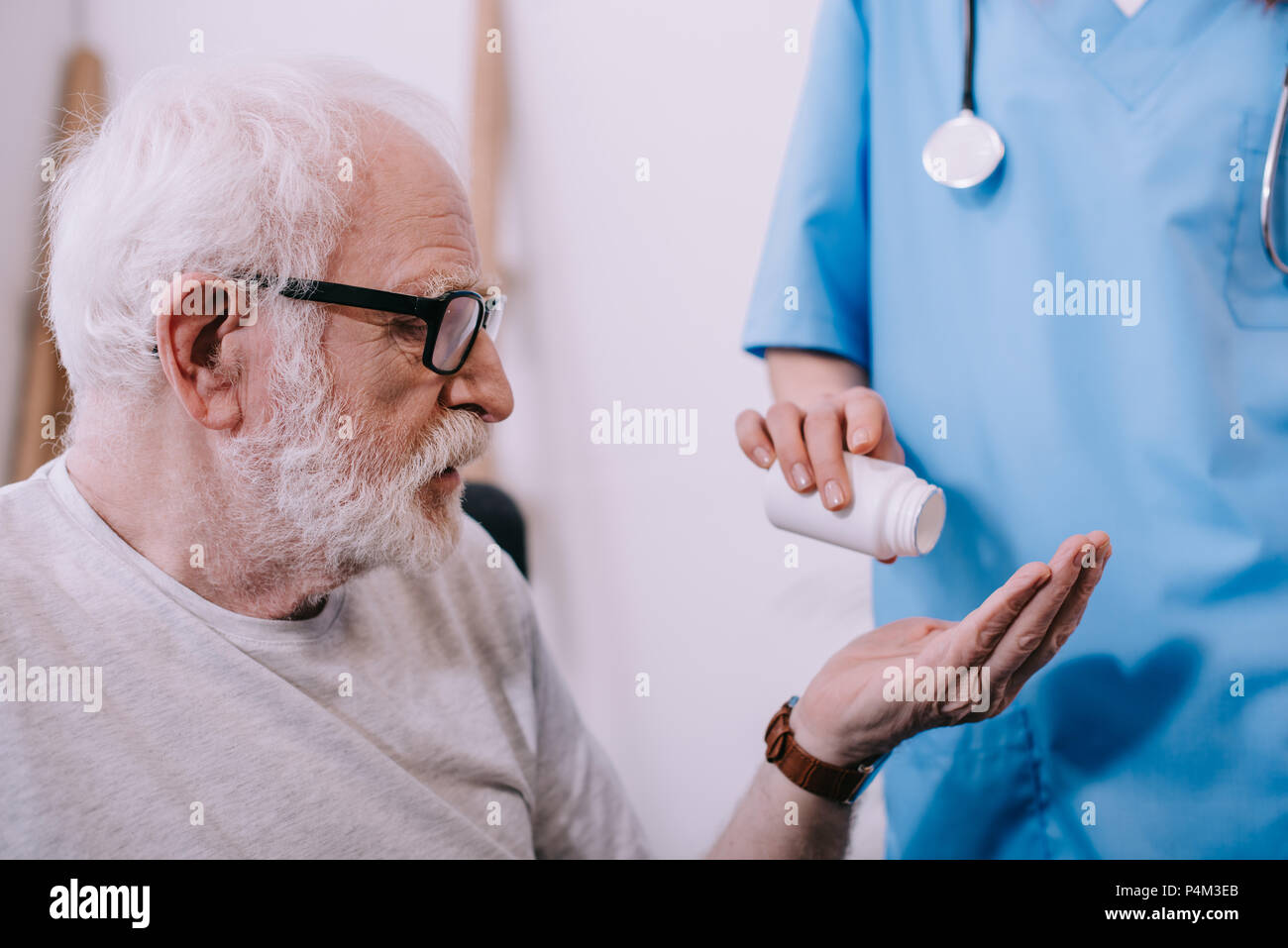 Female nurse giving pills to senior patient Stock Photo - Alamy