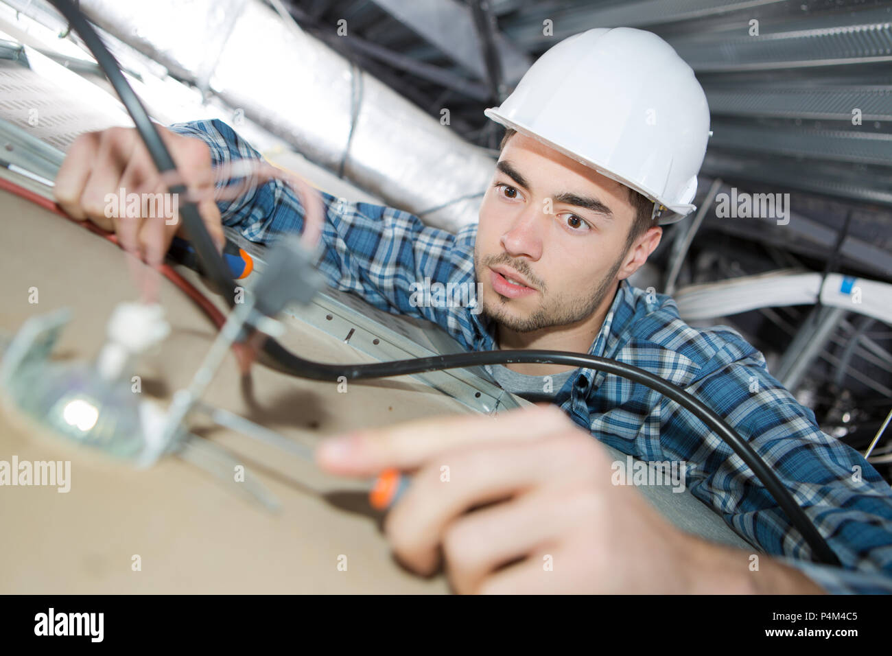 electrician wiring cables in building ceiling Stock Photo - Alamy
