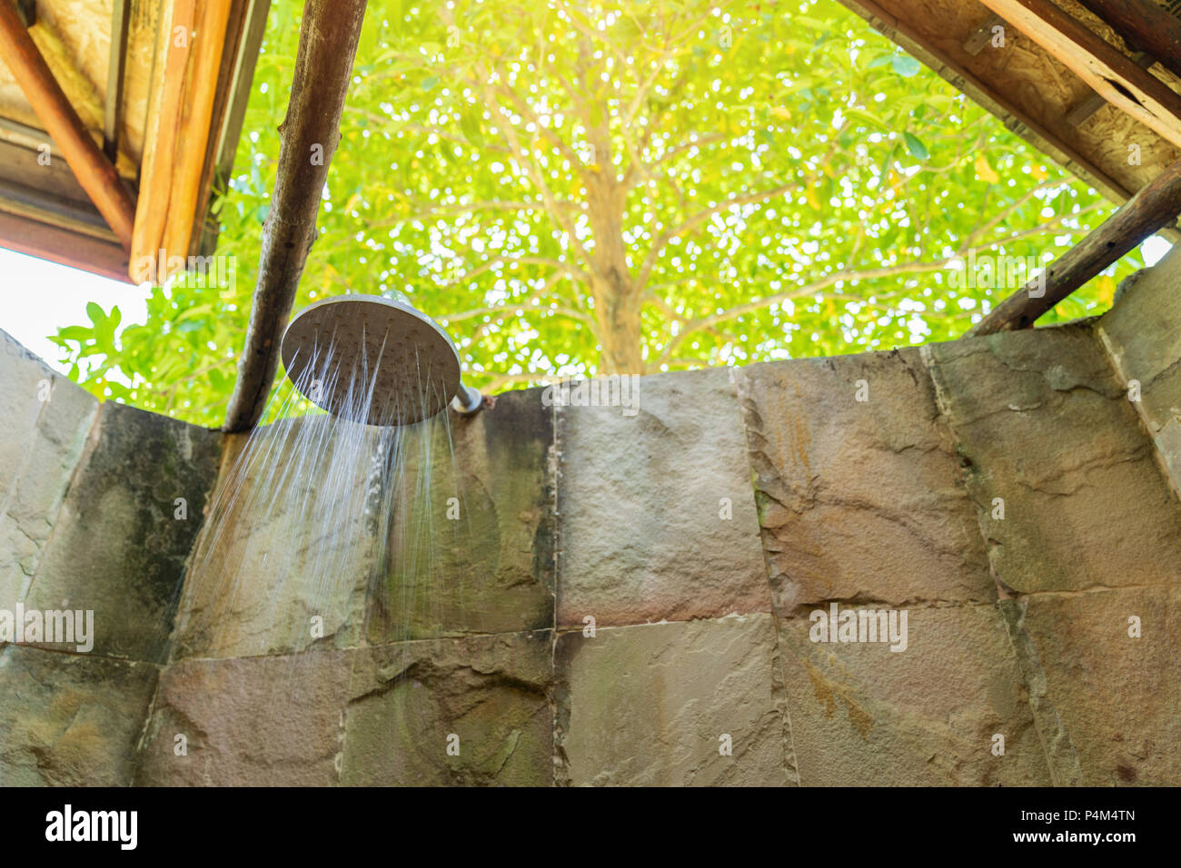 Luxury bathroom with shower outdoors on tree background, sunny light ...