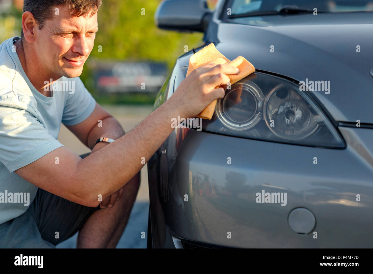 Giving the car a good polish - close up of man cleaning car with ...