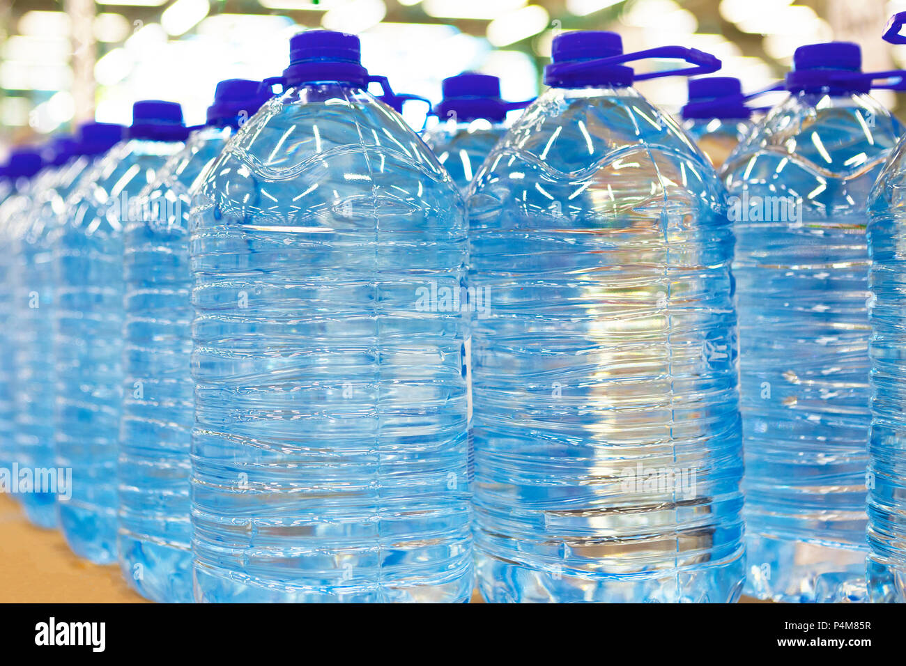 Rows of refreshing natural mineral water in a plastic bottle against ...